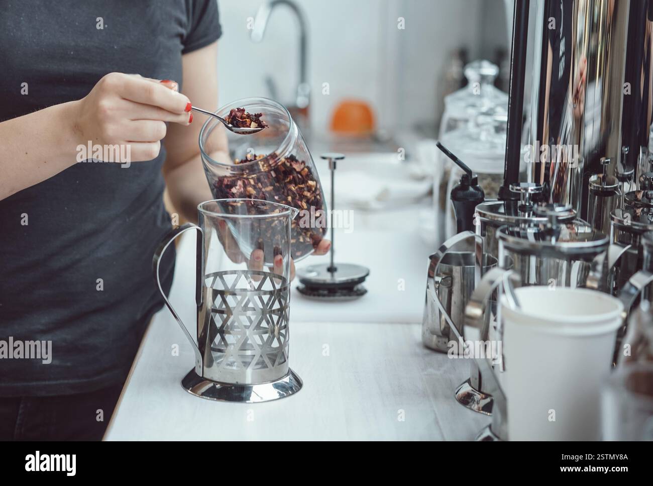 Pour dry tea leaves into the glass container of the tea press maker ...