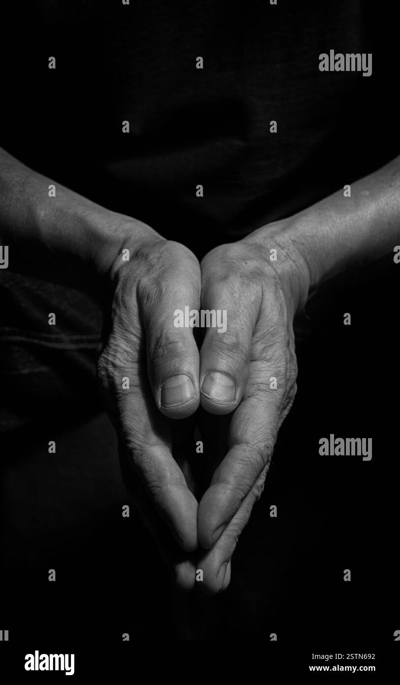 Hands of an old man suffering from severe depression, in black and ...