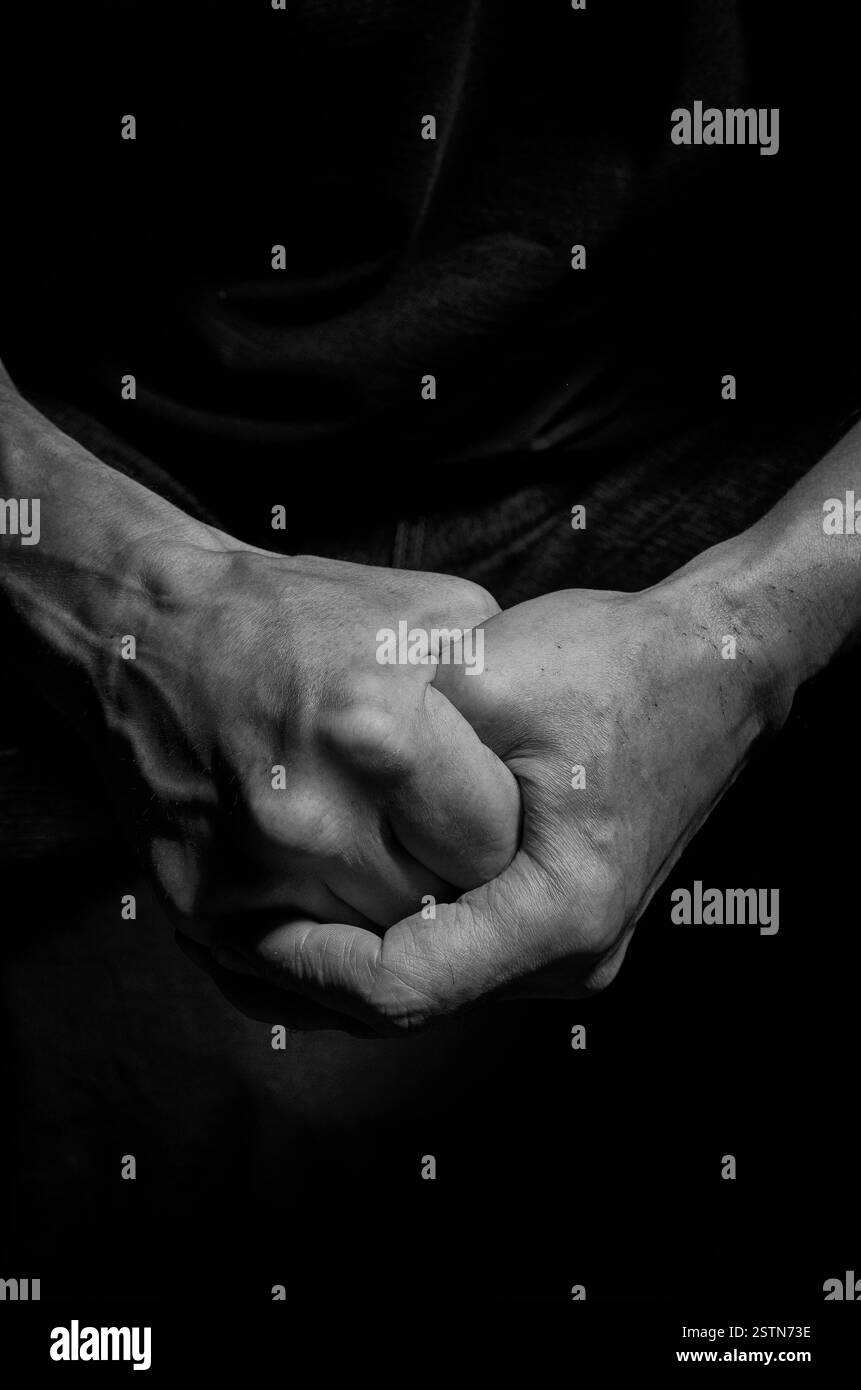 Hands of an old man suffering from severe depression, in black and ...