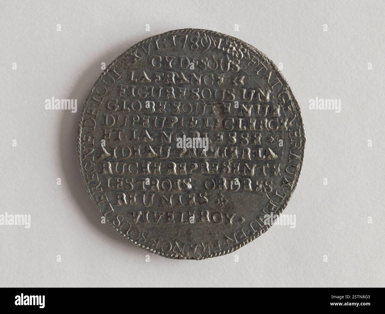 A 1789 coin featuring a peasant of the Third Estate bearing the kingdom ...