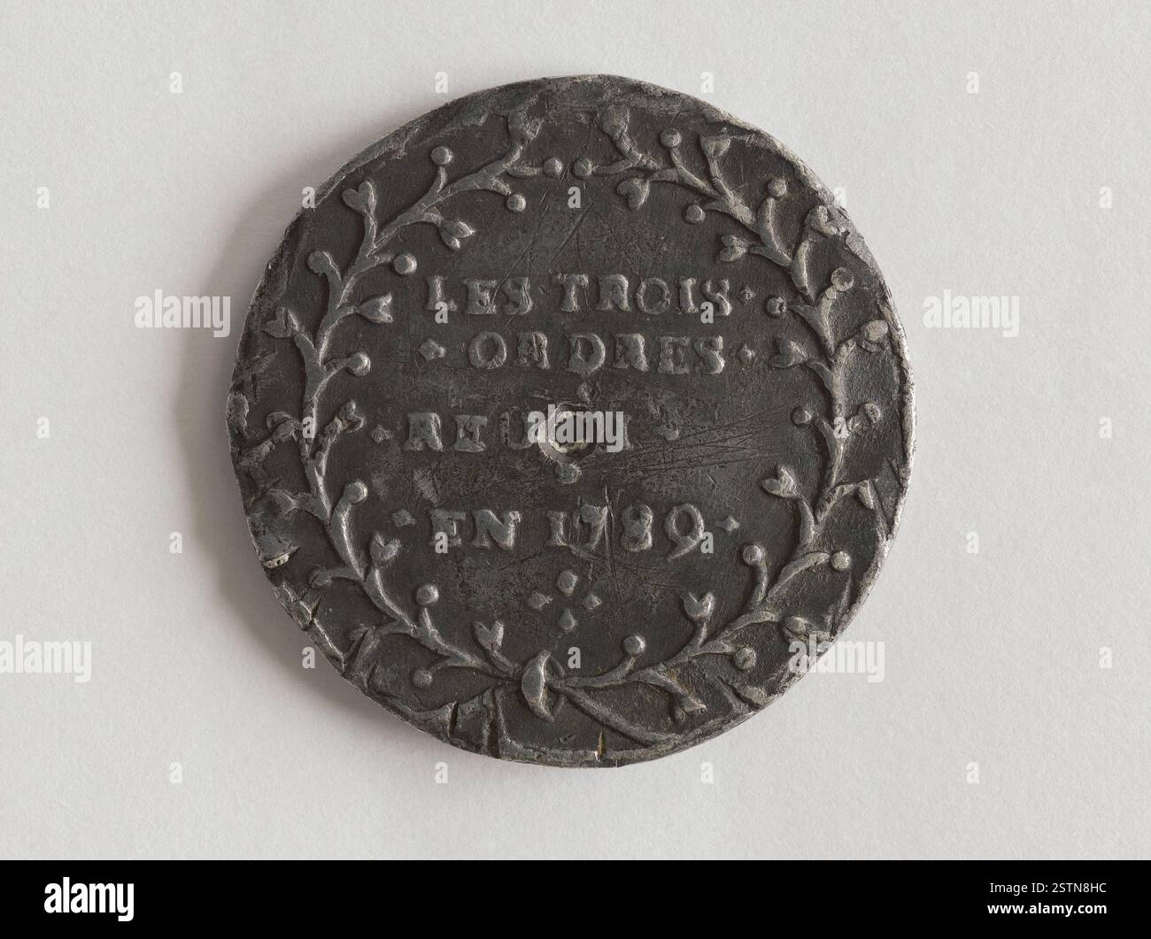 A 1789 numismatic coin showing a peasant bearing the kingdom’s burden ...