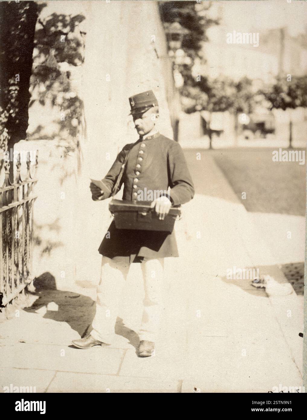 A photograph of a mailman (facteur) in Paris wearing a uniform. The ...
