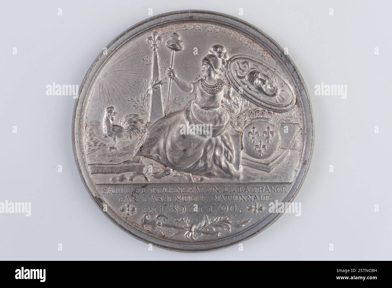This 1790 medal features a crowned, nimbed, and draped bust of Louis ...