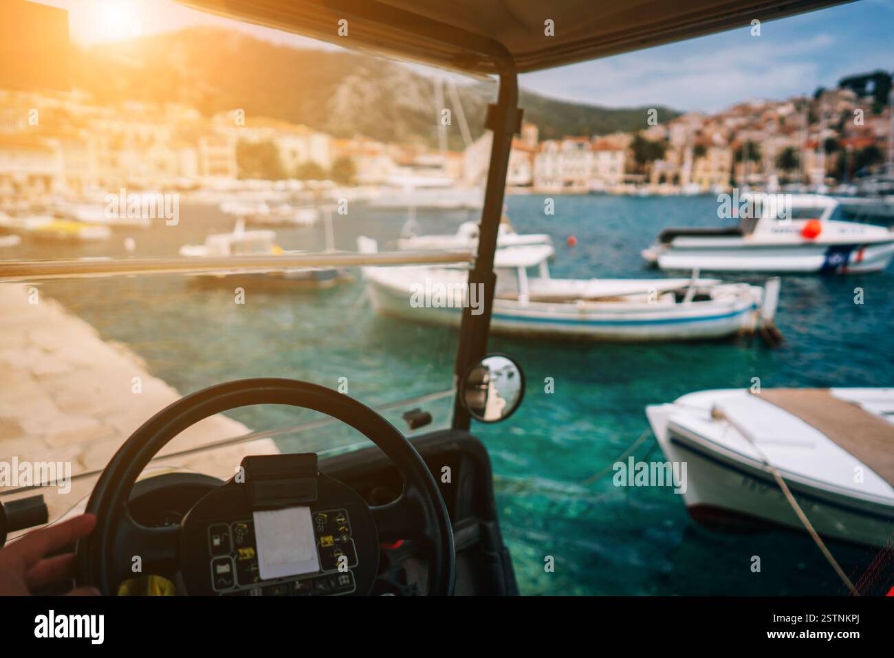 small electric recreational vehicle, in the background, a bay with ...