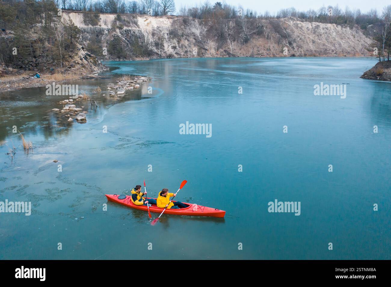 two athletic man floats on a red boat in calm blue waters river Stock ...