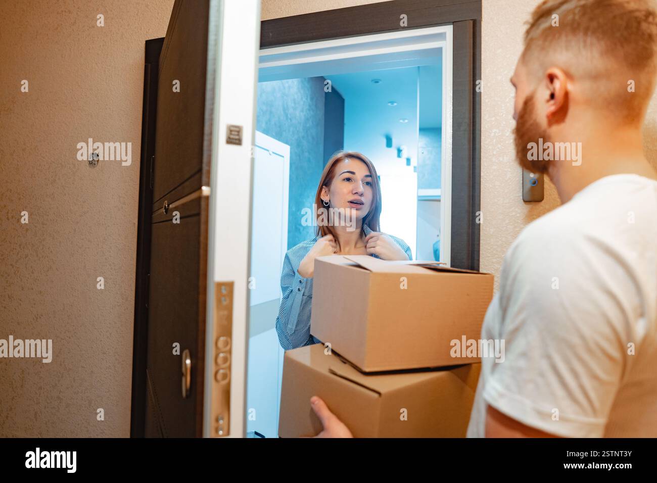 Belivery man delivering parcel box to recipient Stock Photo - Alamy