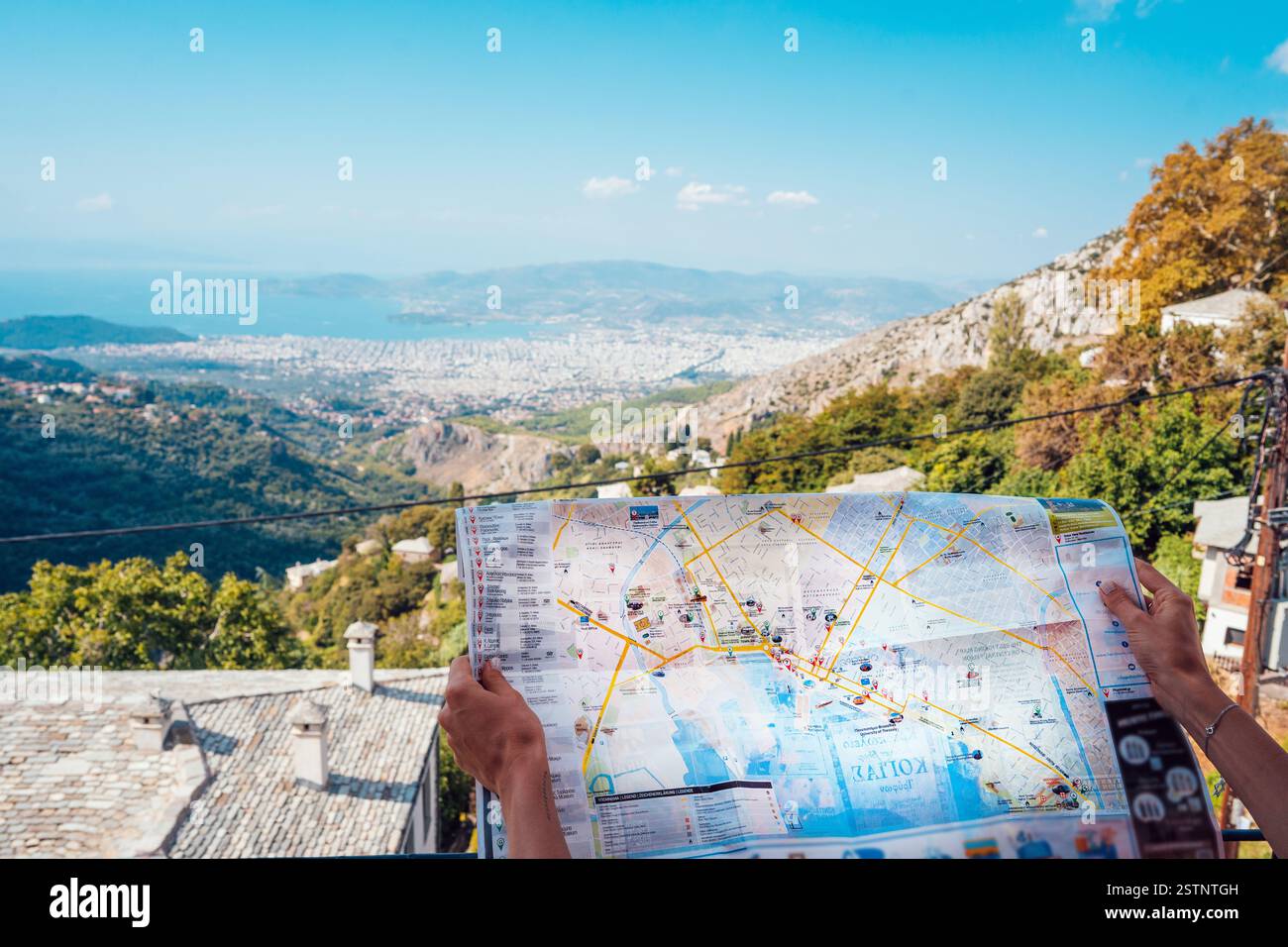 Holding map in hands, city view in background Stock Photo - Alamy
