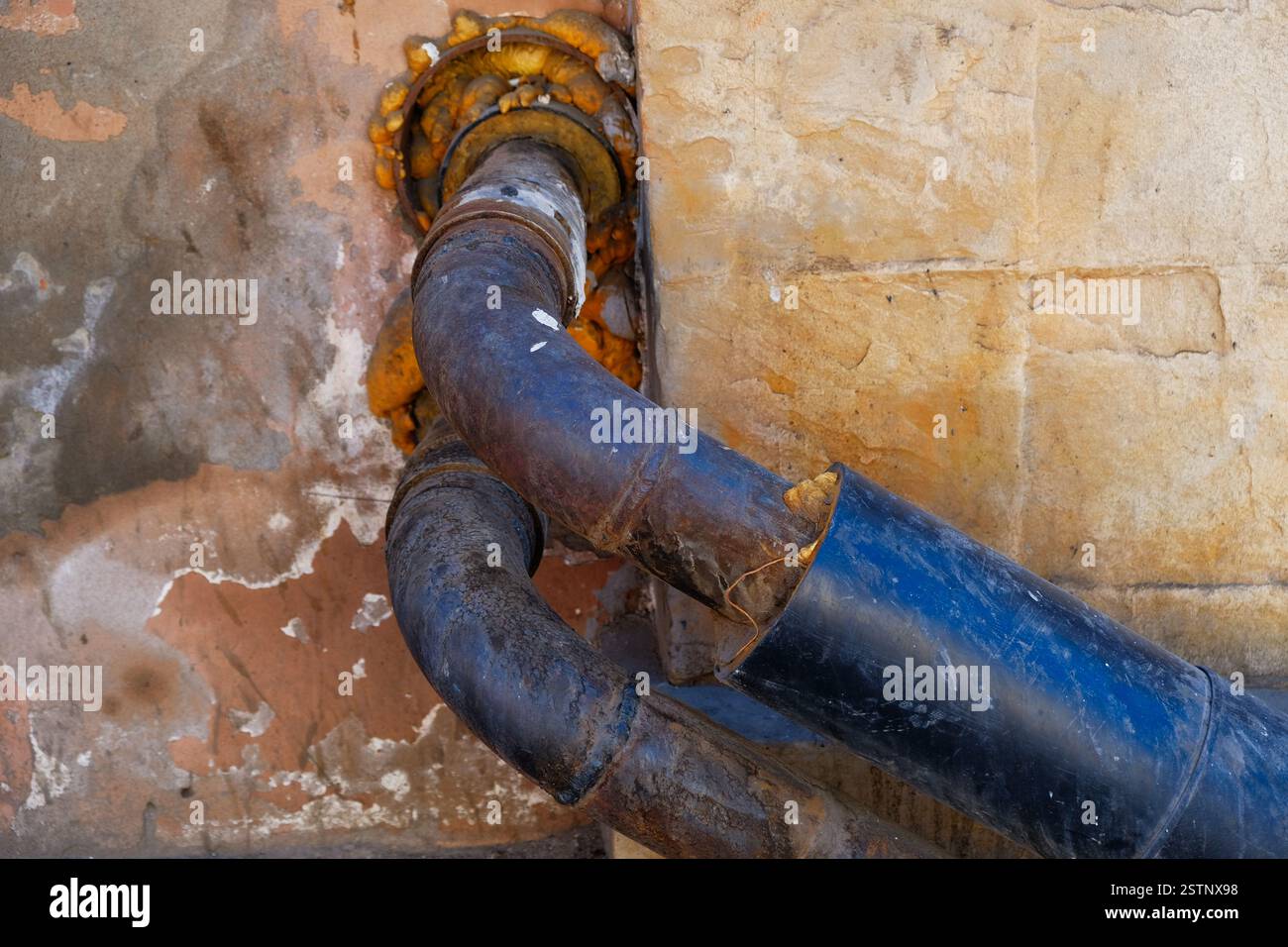 Two old iron pipes connected to wall Stock Photo - Alamy