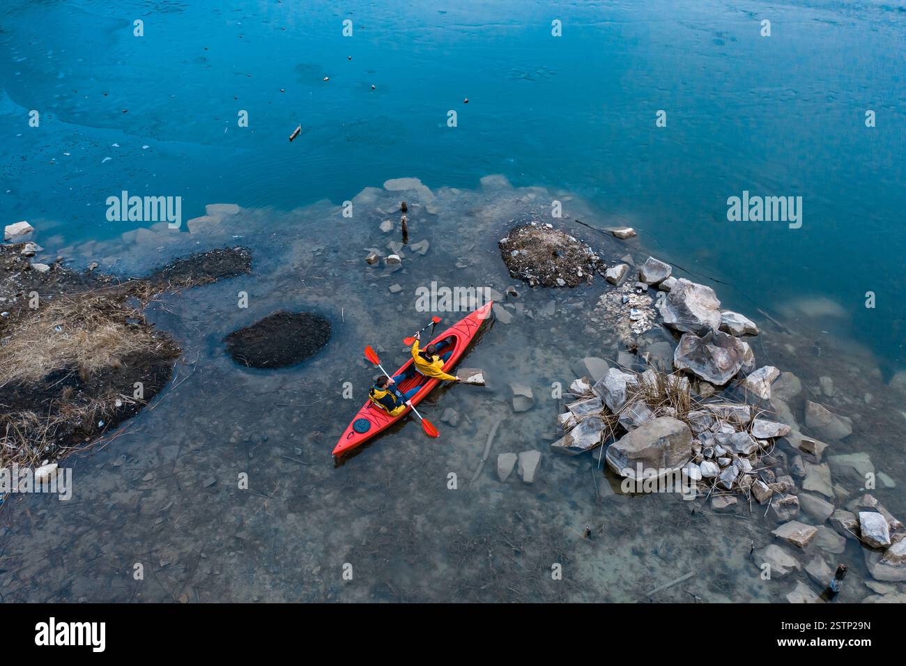 two athletic man floats on a red boat in calm blue waters river Stock ...