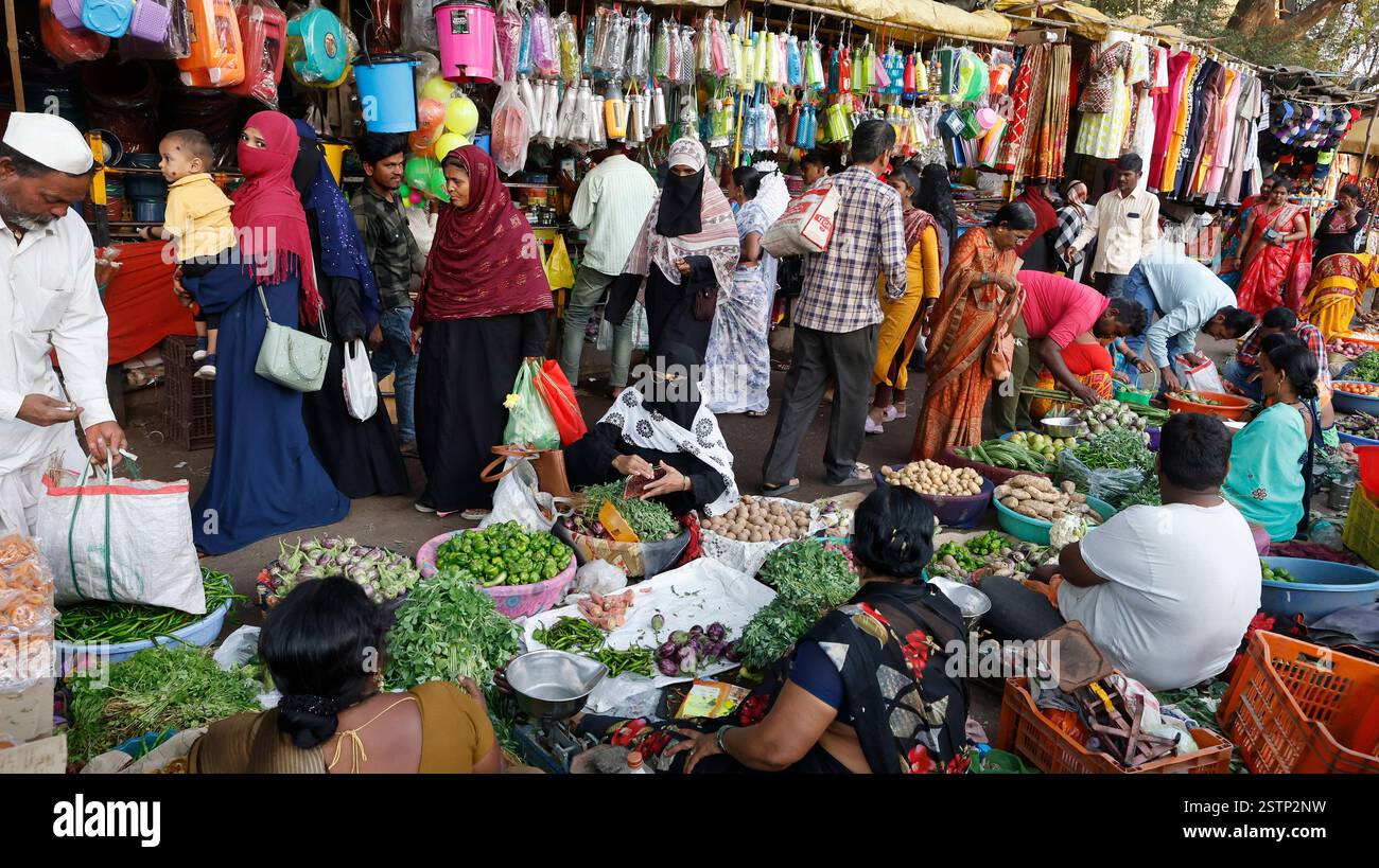 Vegetable sellers and stalls selling household goods in the market at ...