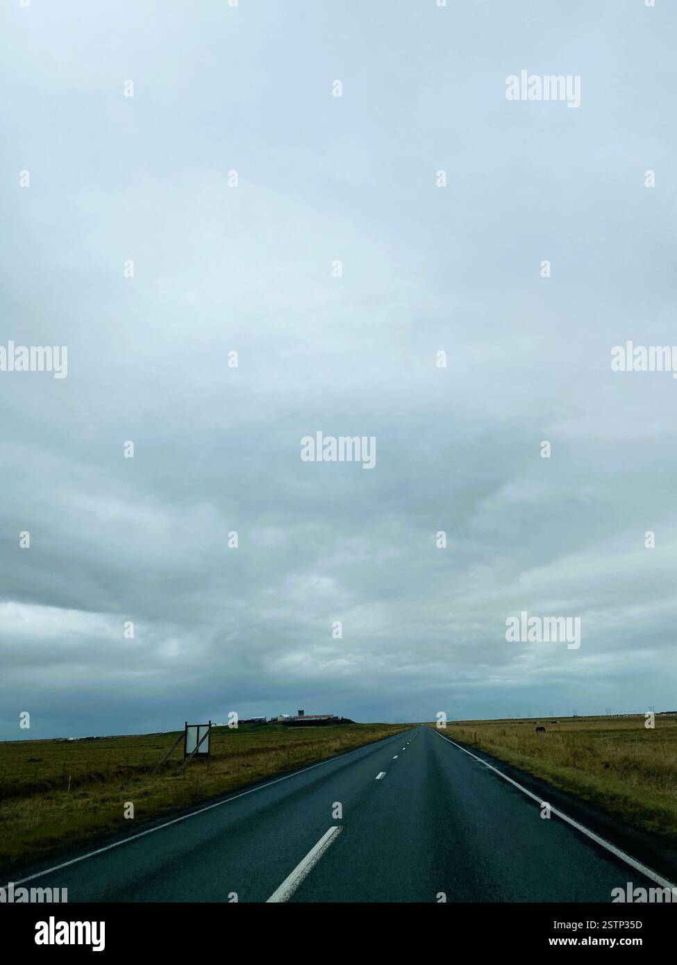 A long, straight road stretches into the distance, surrounded by flat ...