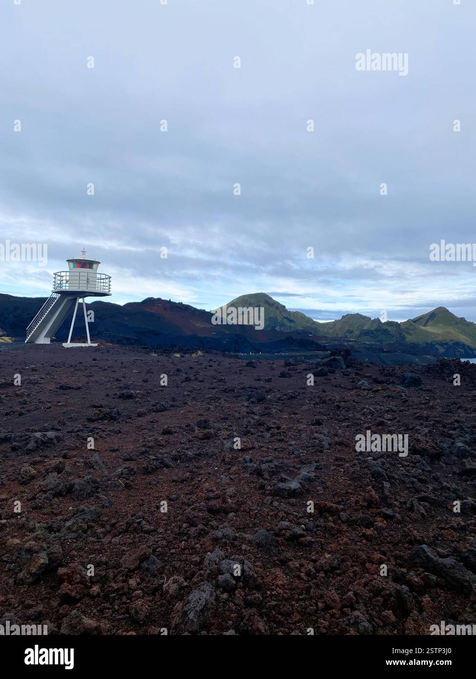 A striking volcanic landscape with rugged terrain, dark lava formations ...