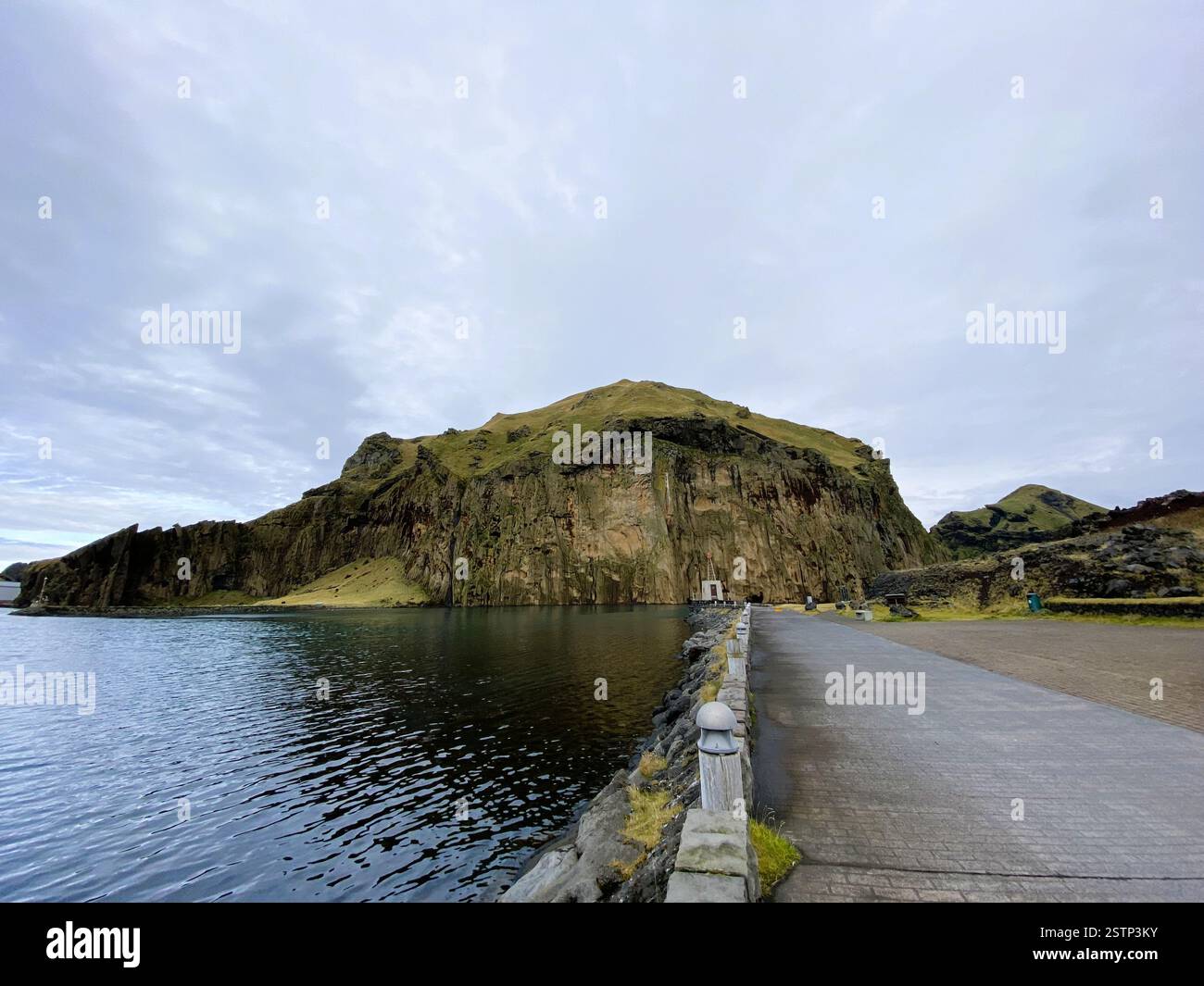 The image depicts a scenic coastal landscape with a steep rocky cliff ...
