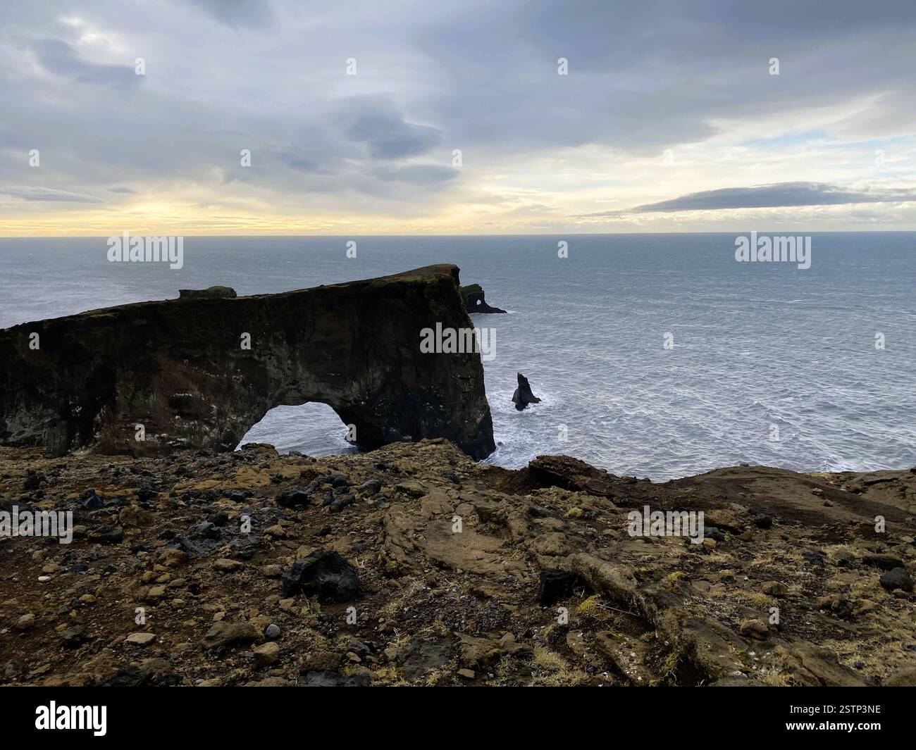A dramatic coastal landscape with rugged cliffs and a prominent rock ...