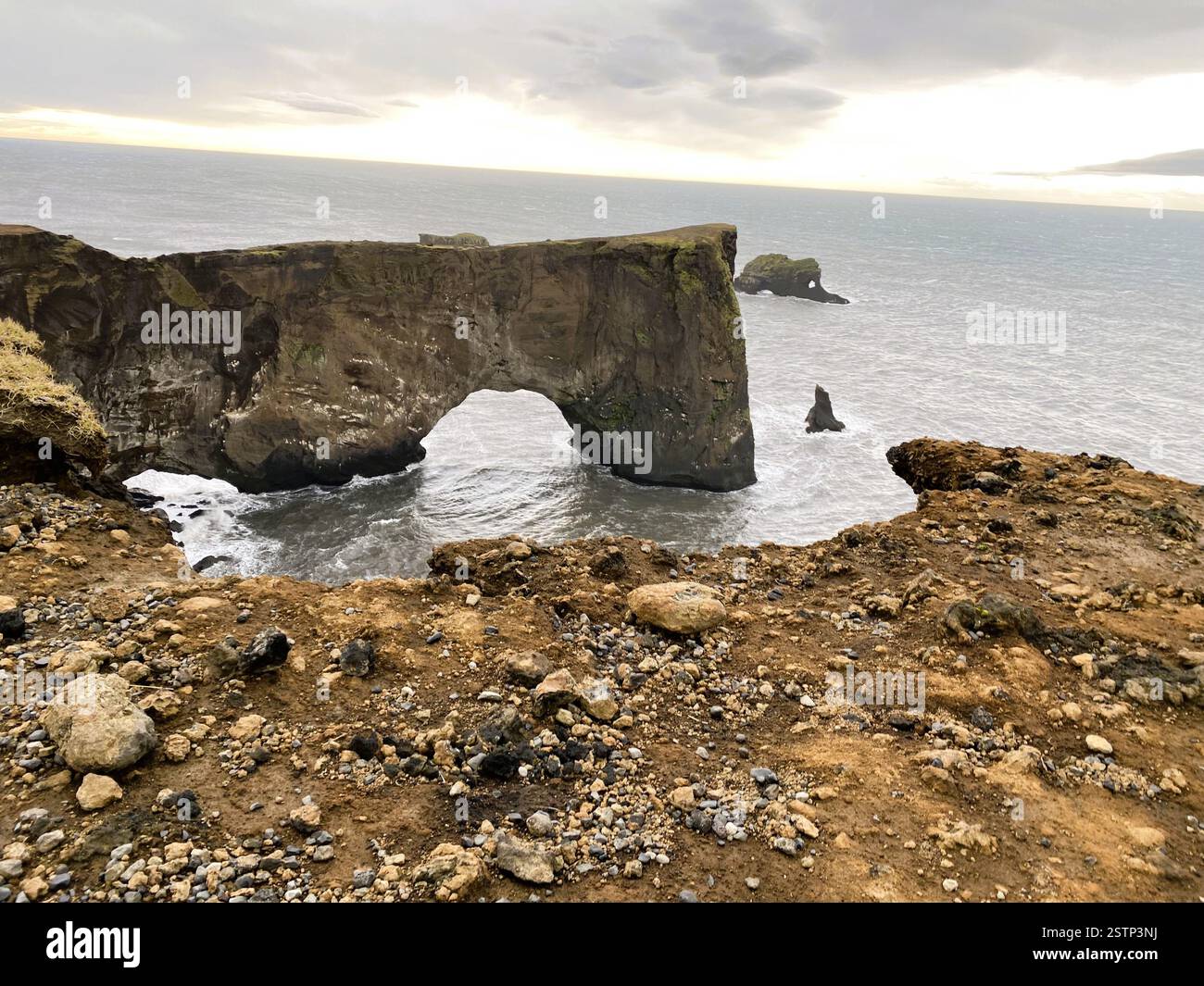 A stunning coastal scene featuring a natural rock arch, dark volcanic ...