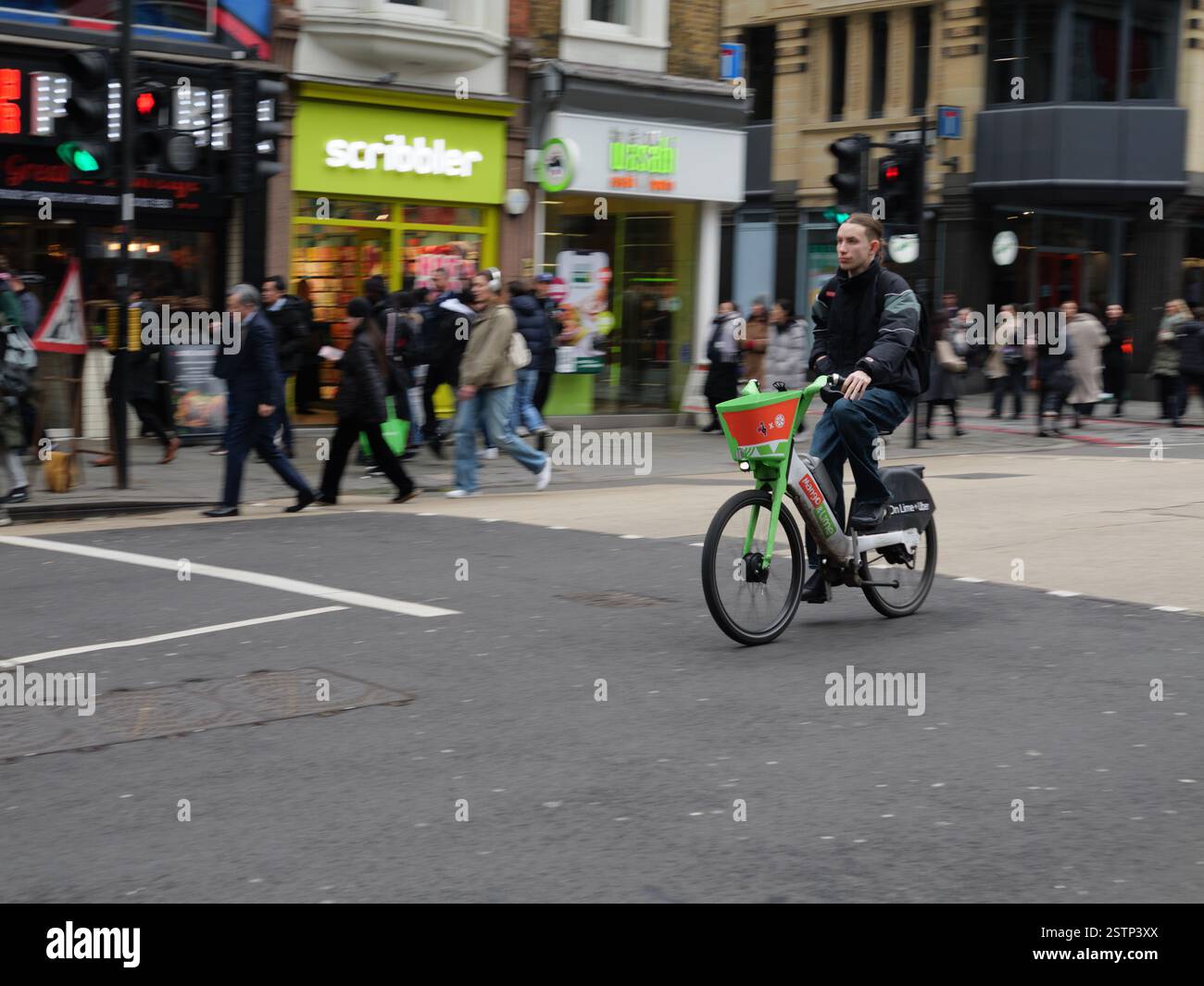 Lime rental bike rider, rides down Bishopsgate London UK, with one hand ...