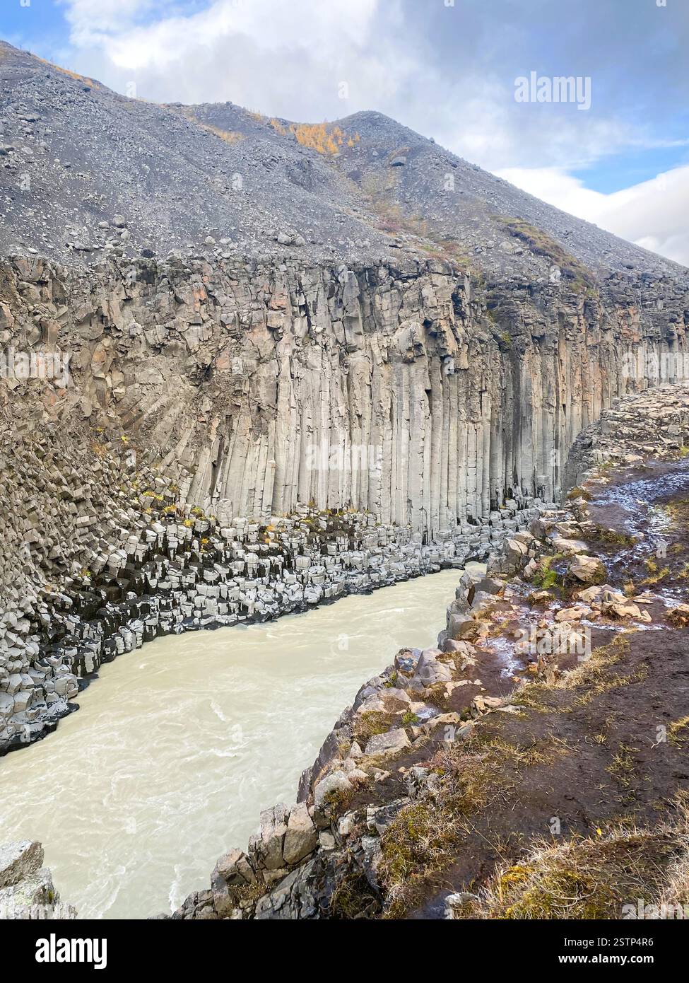 The image depicts a striking natural landscape characterized by a dramatic geological formation ...