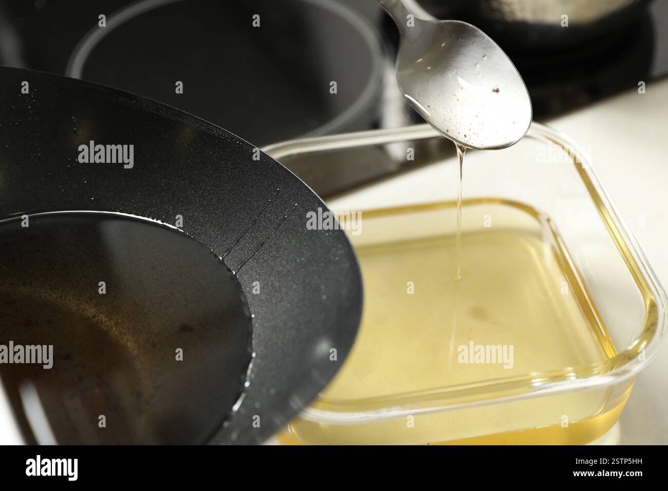 Pouring used cooking oil at white countertop, closeup Stock Photo - Alamy
