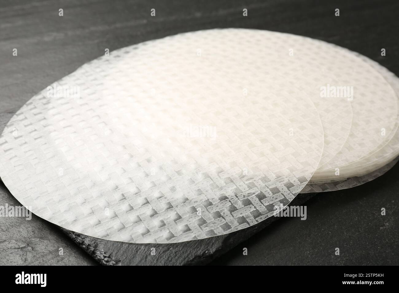 Edible rice paper sheets on dark textured table, closeup Stock Photo ...