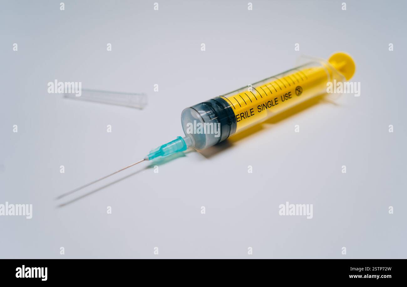 One one-off yellow medical syringe with needle lying Stock Photo - Alamy