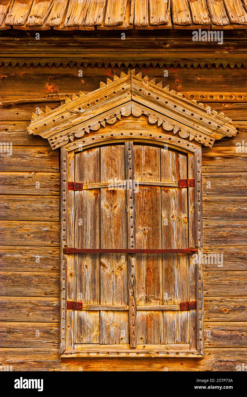 Traditional russian wooden window with closed shatters in warm tones ...