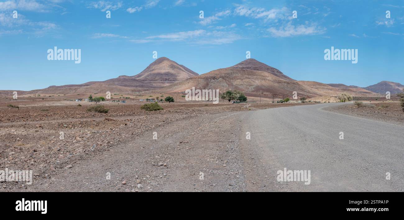 cityscape with very small village and C39 dirt road bending in desert ...