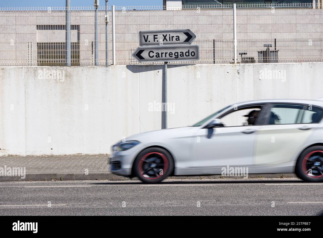 Fast white car driving near a road sign indicating vila franca de xira ...