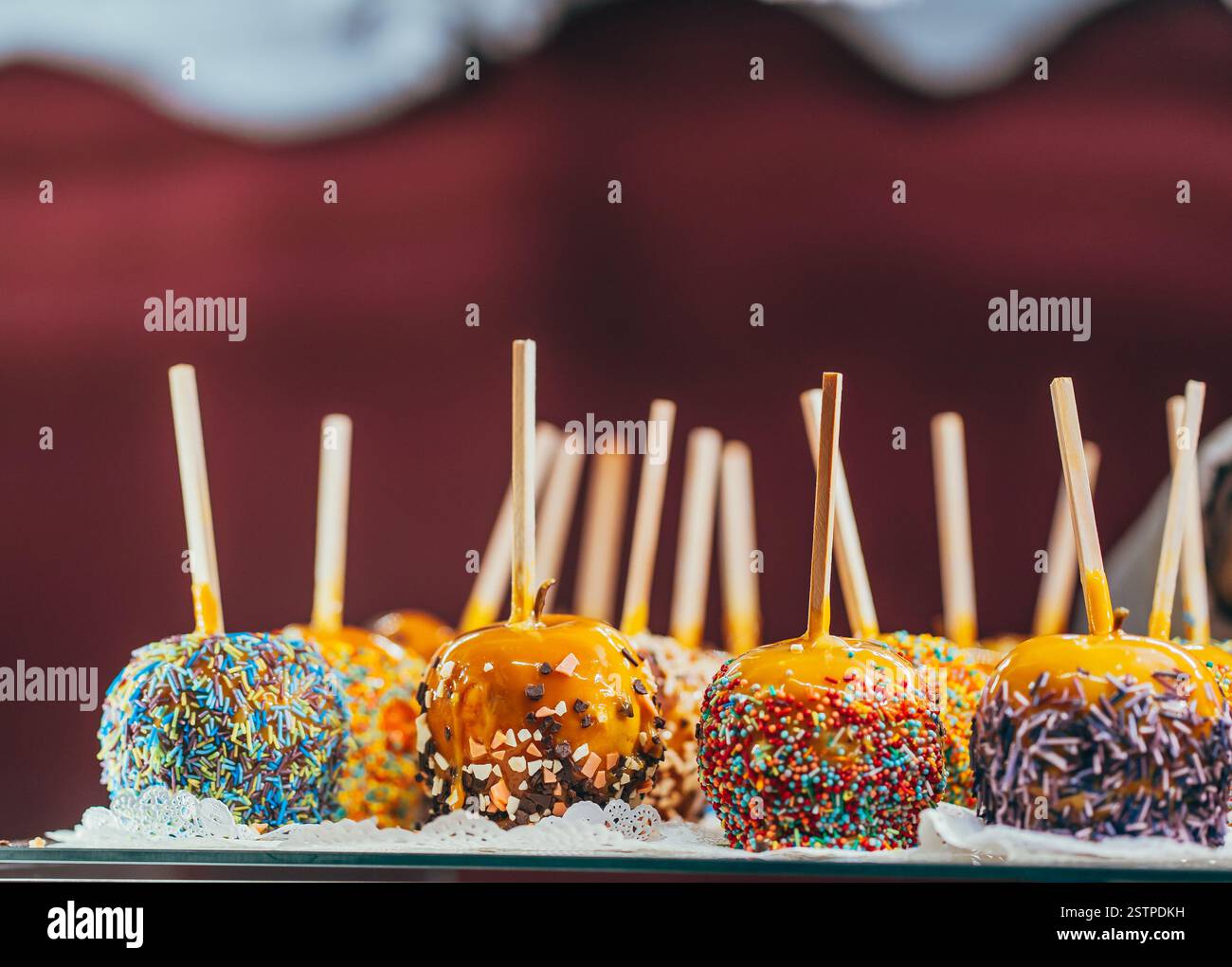 Apples in caramel and sprinkles. Street food Stock Photo - Alamy