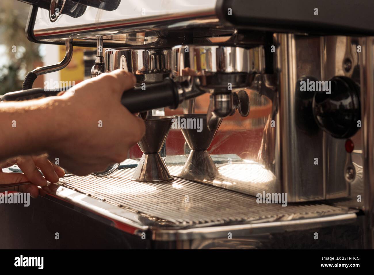 Smallbusines owner preparing espresso using chromed coffee machine side ...