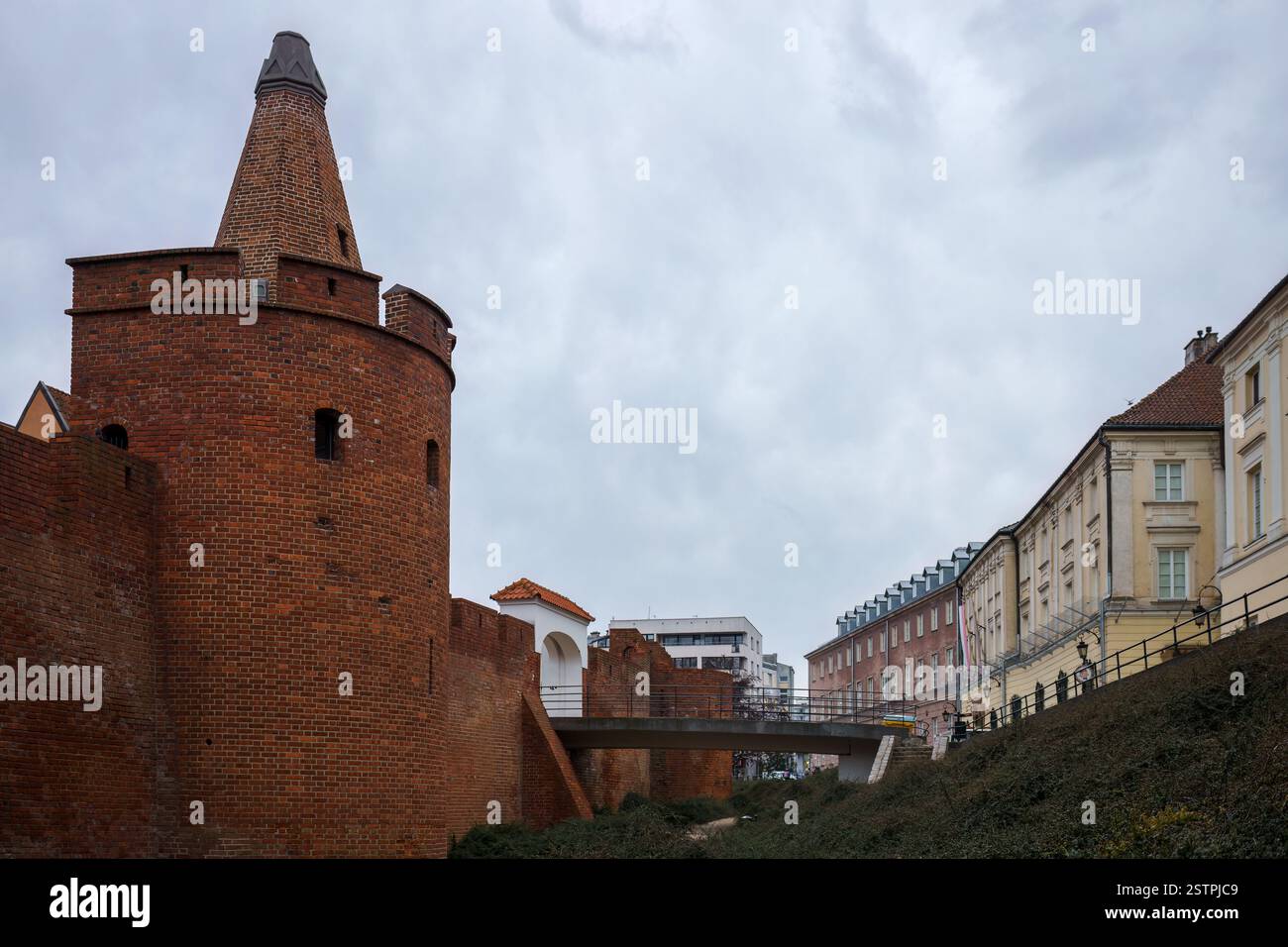 Historical red brick tower of Warsaw Barbican next to colorful houses ...