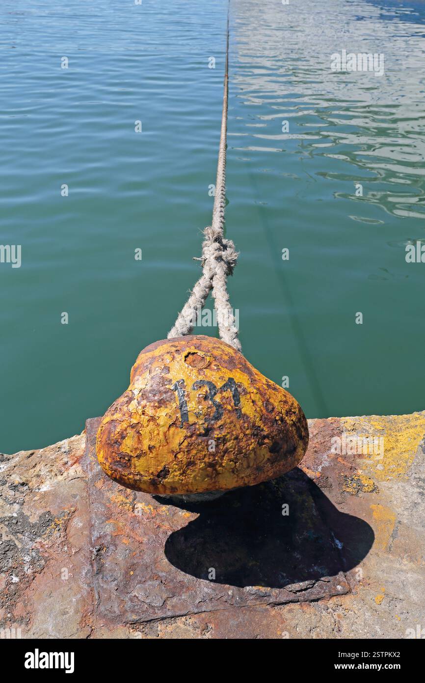 Rusty mooring bollard with long rope in port hi-res stock photography ...