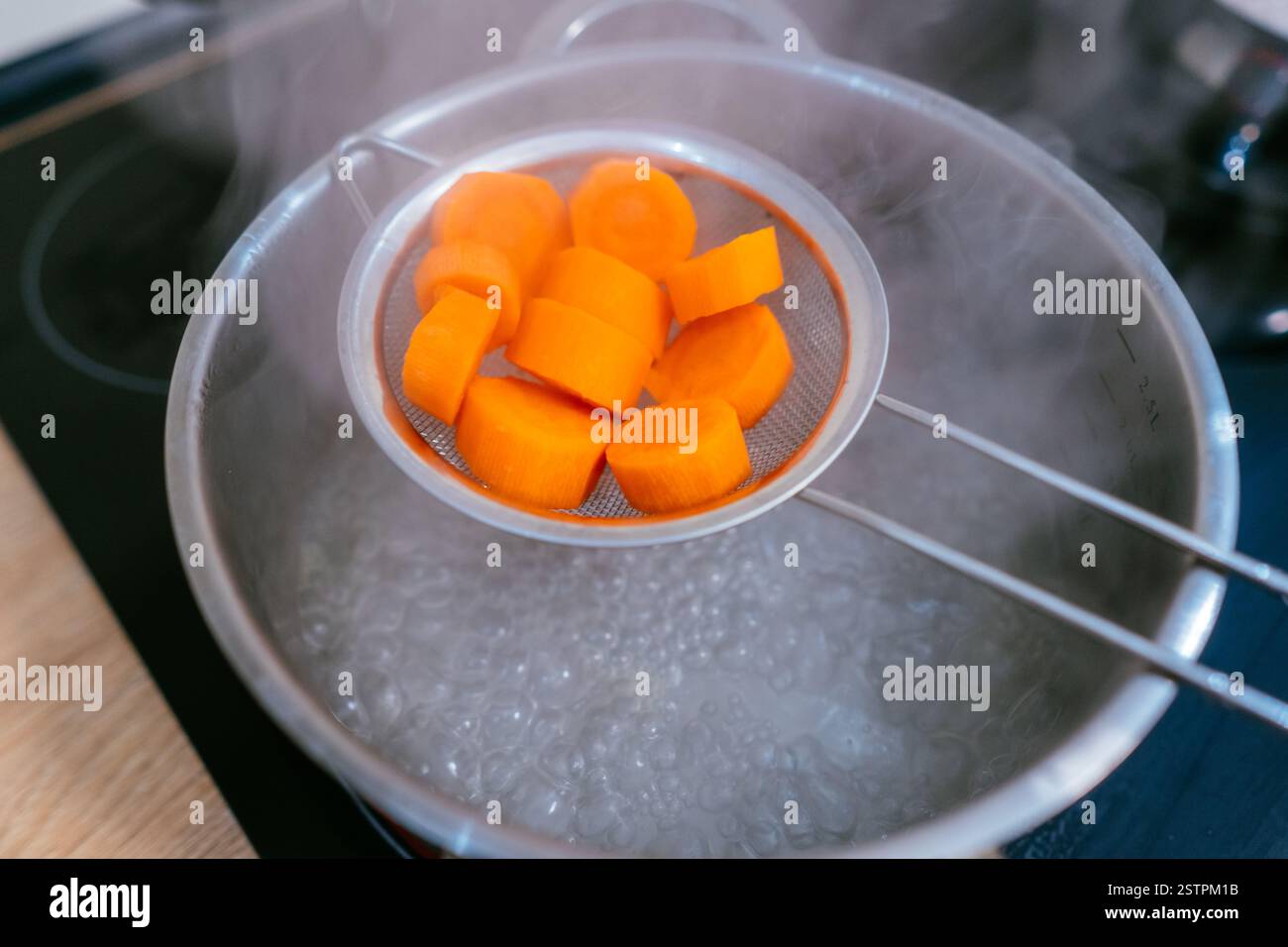 The image of a small amount of chopped carrots over a boiling pan Stock ...