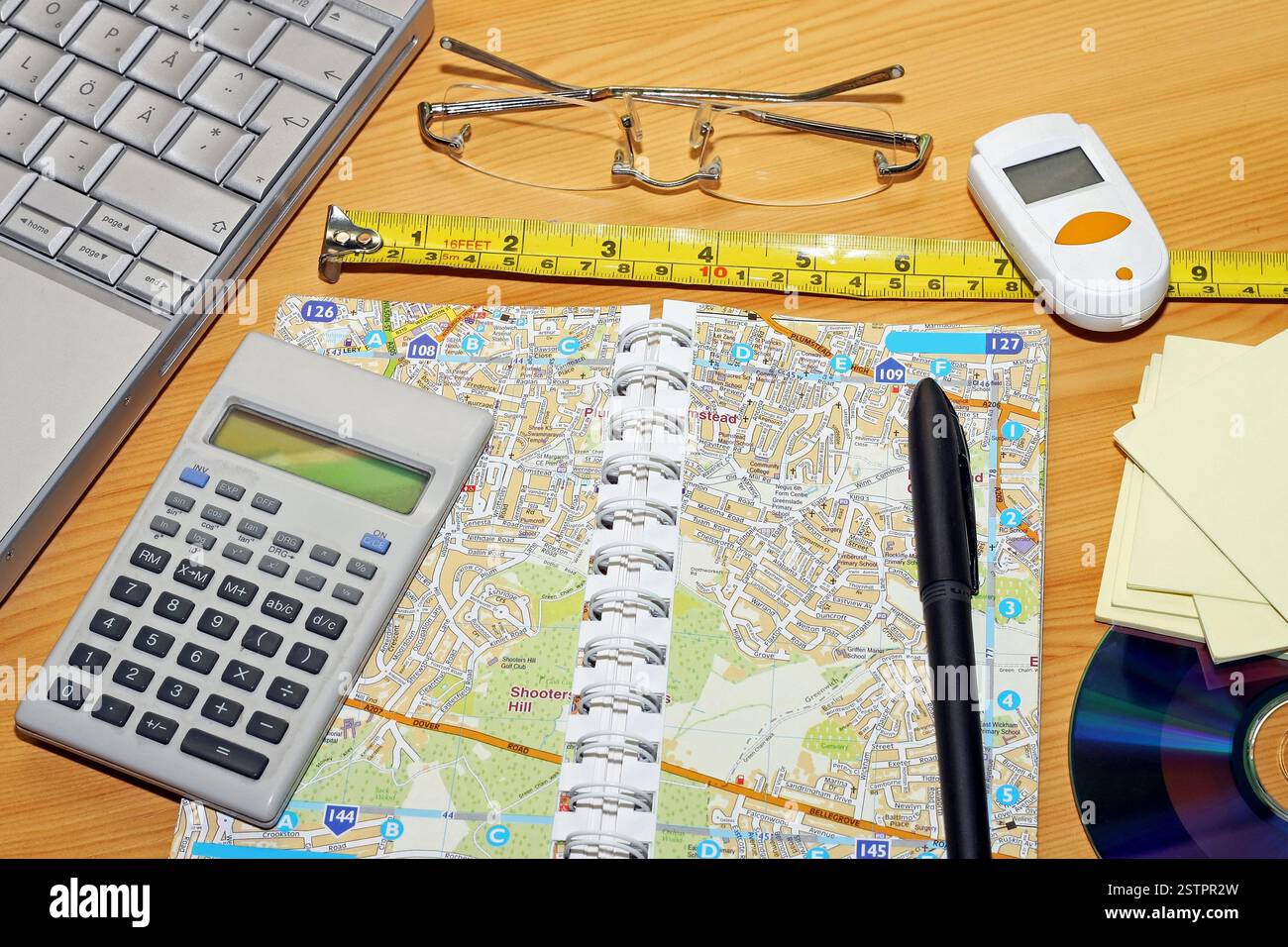 Calculator and map navigation at wooden desk hi-res stock photography ...
