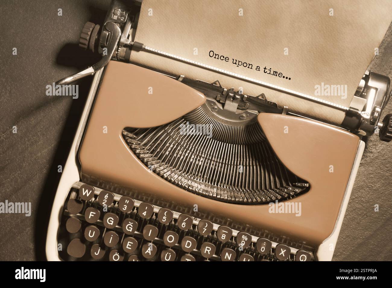 Typewriter with sheet of paper on table, top view. Typed text Once Upon ...