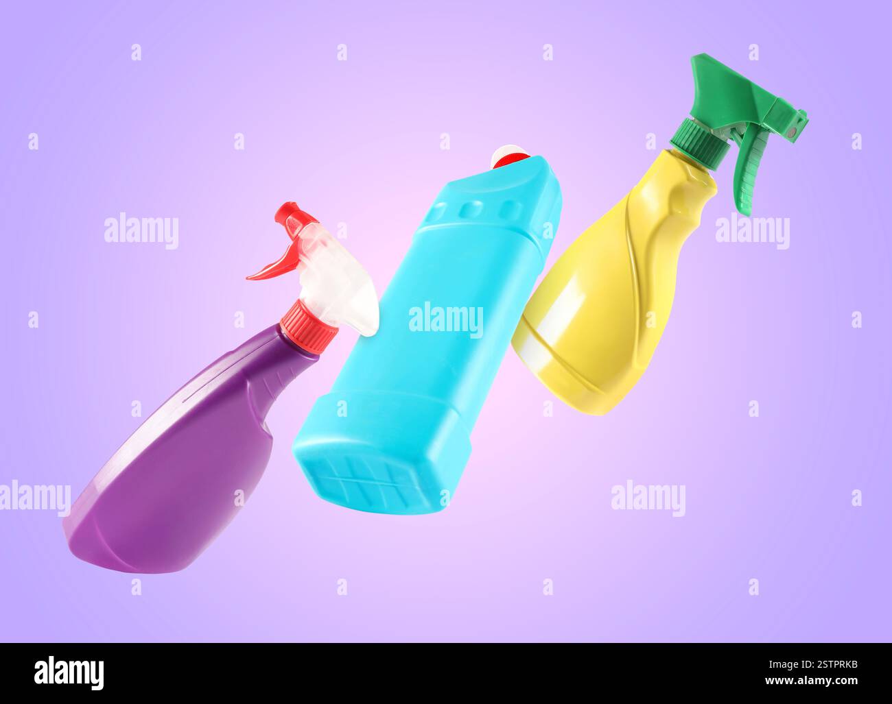 Different cleaning products in air on violet background Stock Photo - Alamy