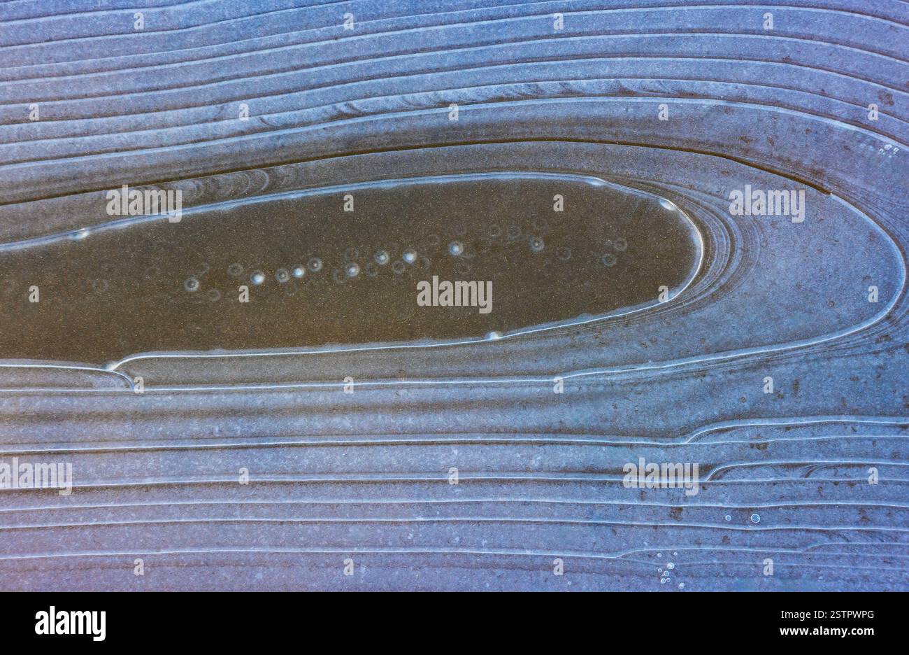 Frozen water on the ground, pattern of ice Stock Photo - Alamy