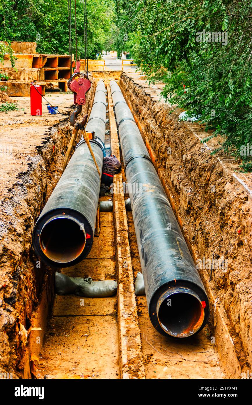 Two New heating water tube pipe in trench covered with black heat isulation Stock Photo - Alamy