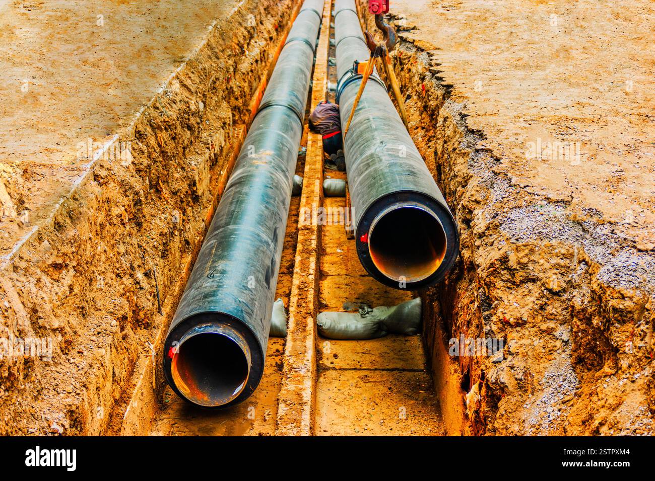 Underground pipe being fixed in trench. Man do a circular welding in ...