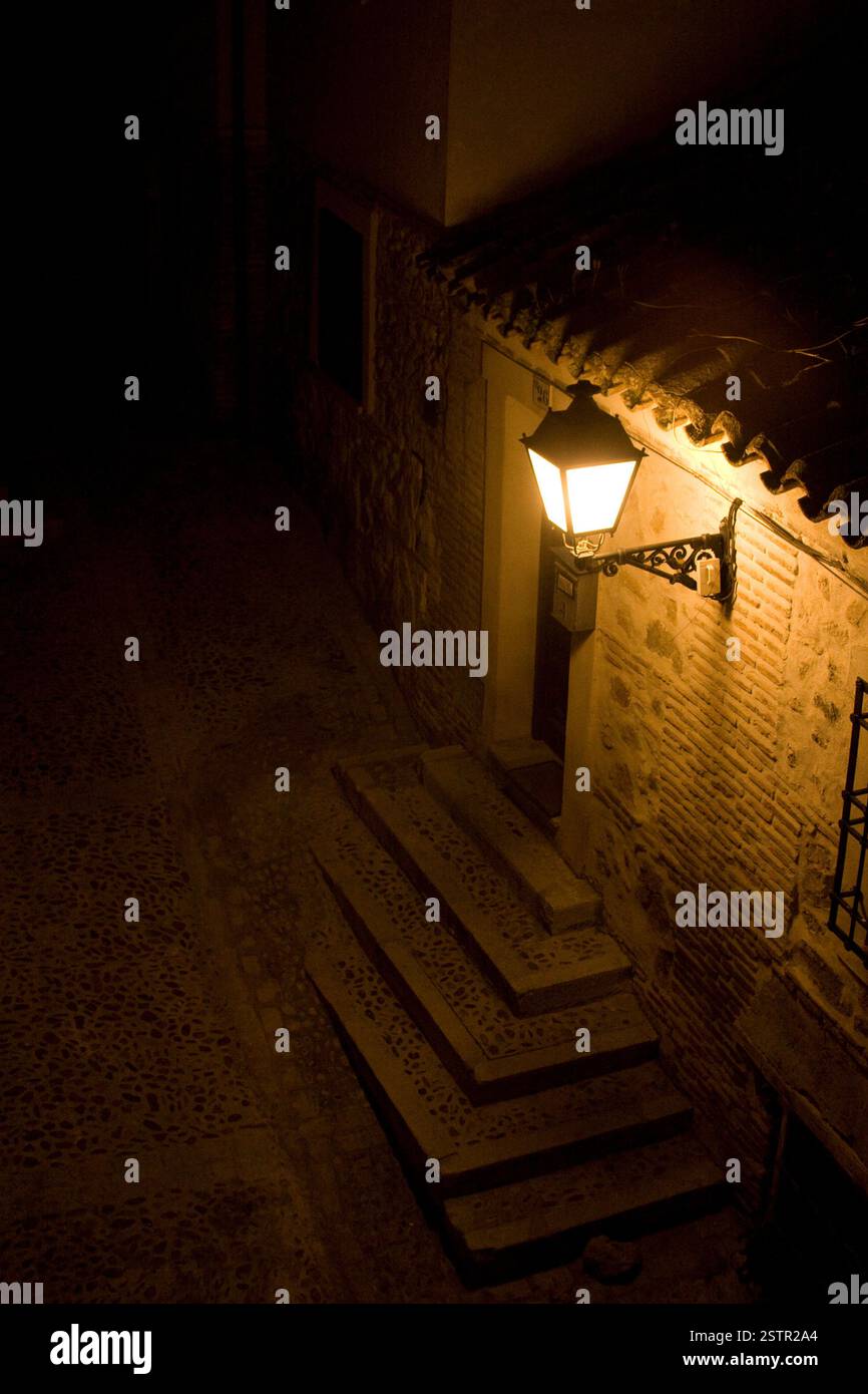 Stone steps lit by a street lamp in a dark alley. Urban detail ...