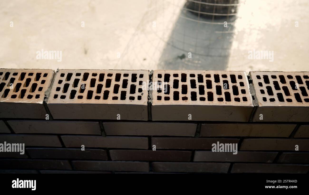 Close-up of a brick wall under construction, featuring ventilation bricks ensuring proper ...
