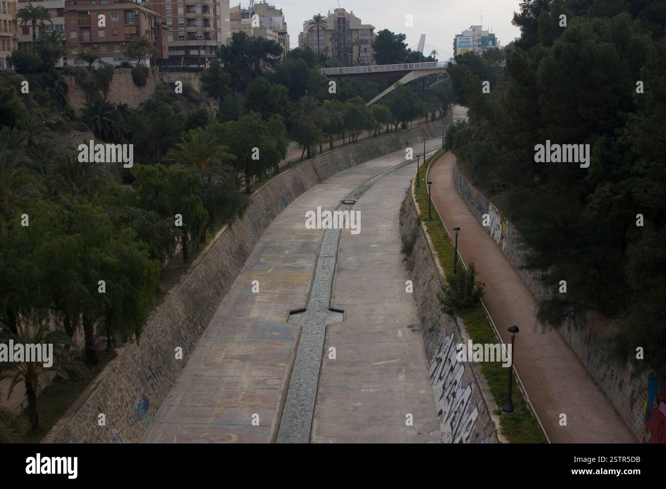Urban landscape with a concrete channel and surrounding vegetation ...