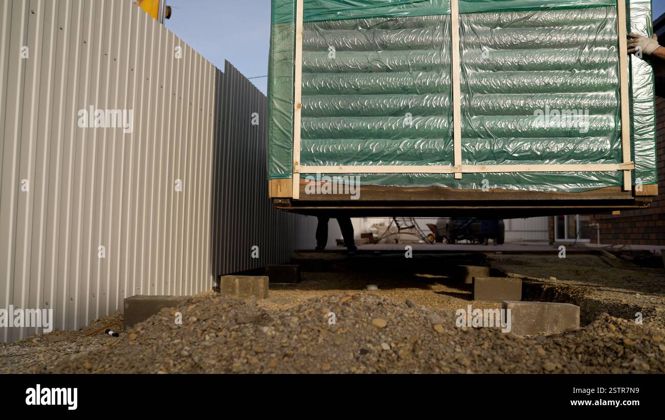Builders are lifting prefabricated tiny house module during ...