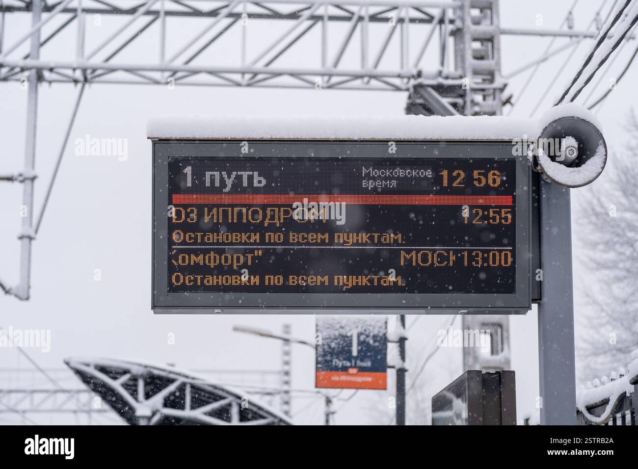 Train schedule display shows arrival times in snowy conditions at a ...