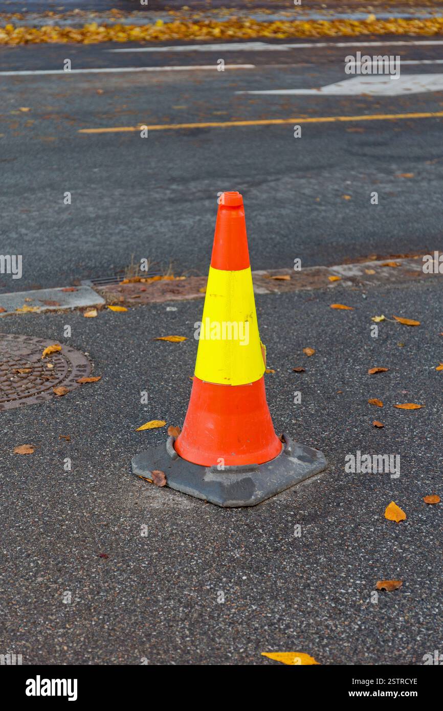 One fluorescent traffic cone at street pavement hi-res stock ...