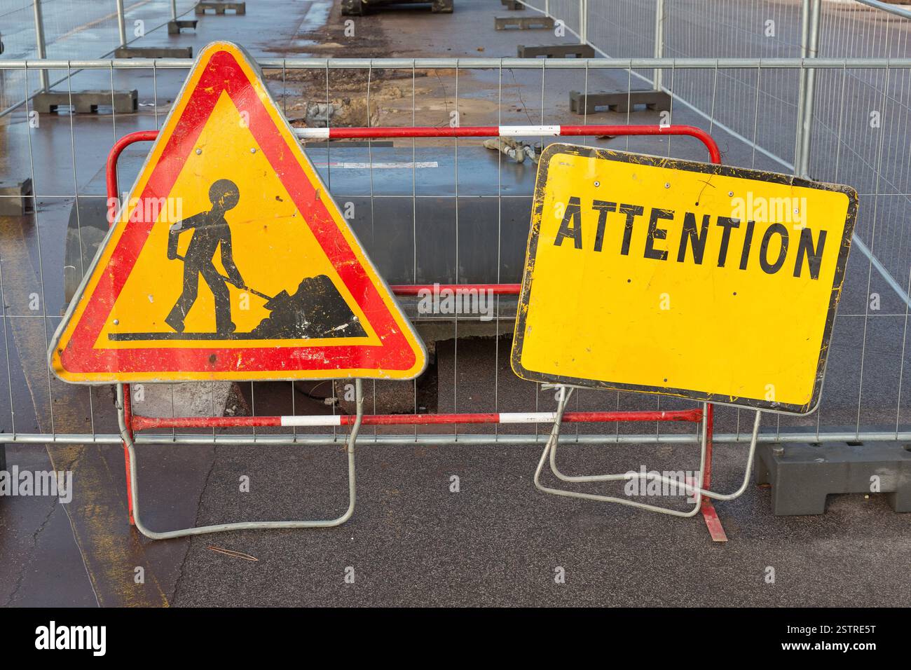 Construction site barrier with yellow warning sign hi-res stock ...