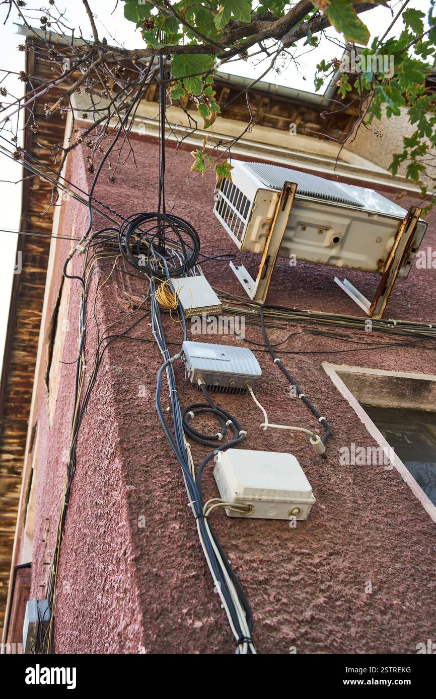 Telephone and communication cables and electrical wires on the facade ...