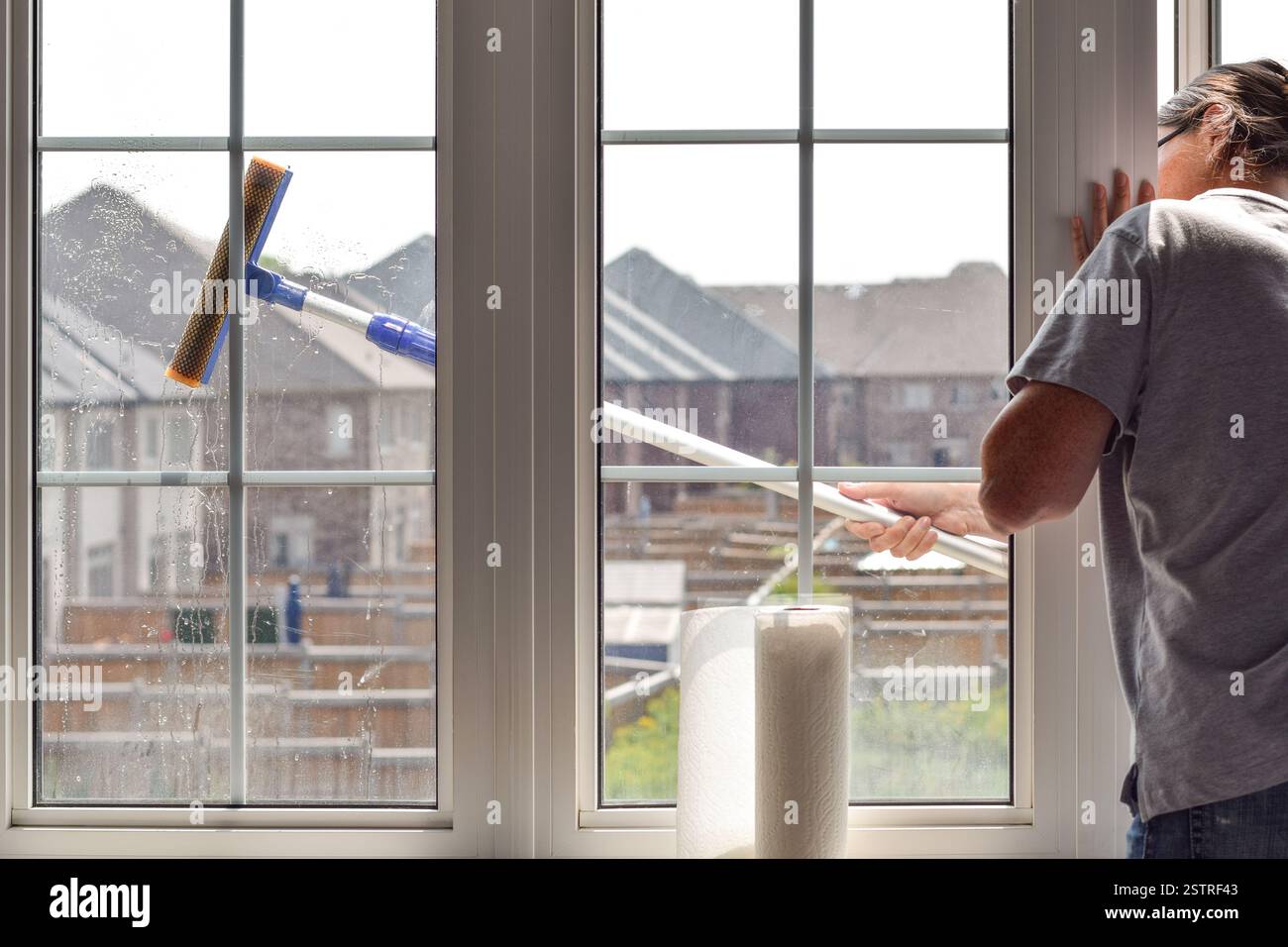 Woman washing dirty windows with extendable telescopic window cleaning ...