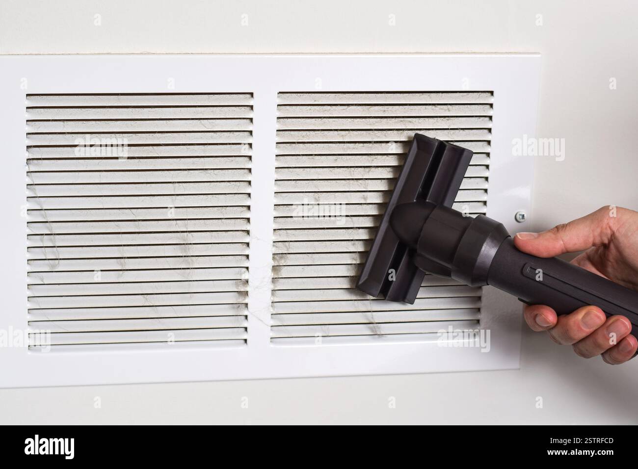Person's hand vacuuming dirty return air vents Stock Photo - Alamy