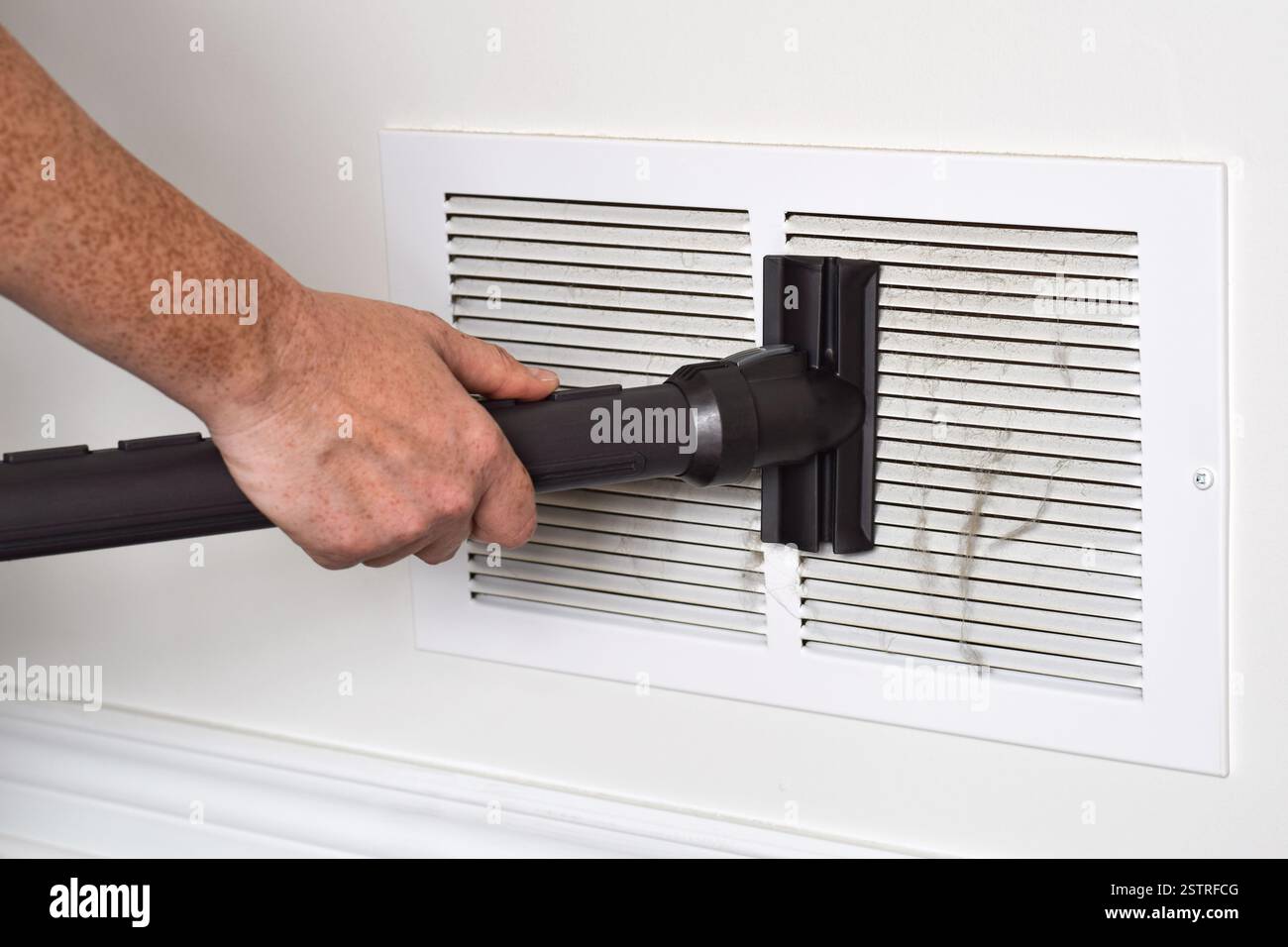 Person's hand vacuuming dirty return air vents Stock Photo - Alamy
