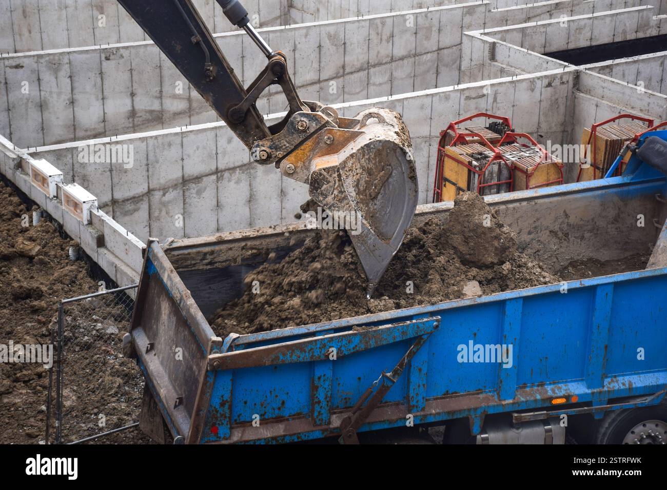 Exavator digging and unloading dirt into dump truck at construction ...